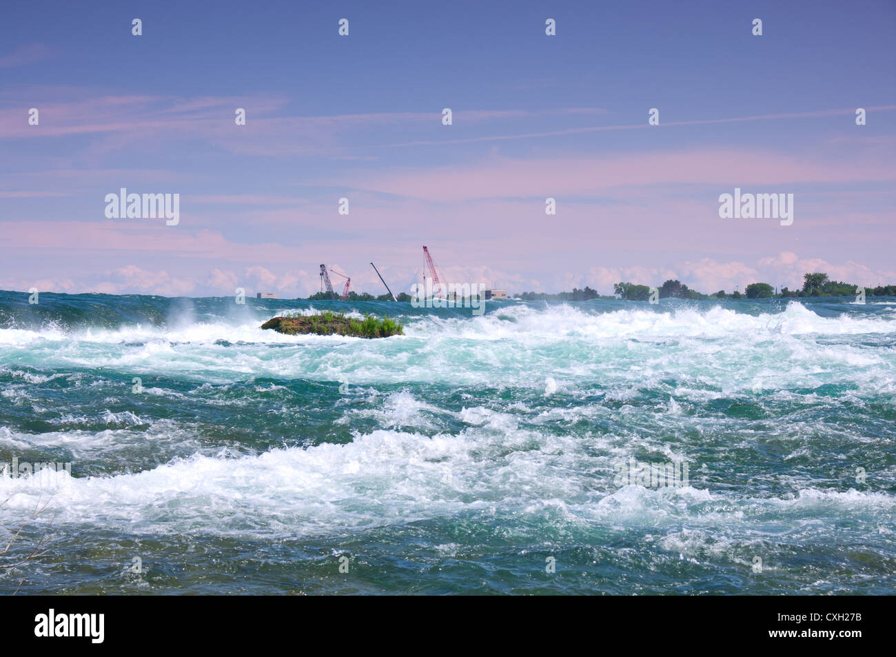 Rapids of Niagara River above falls with construction cranes near ...