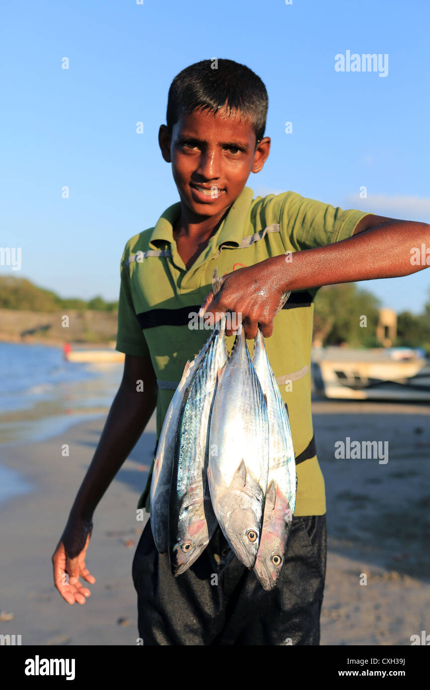 Sri Lankan boy holding freshly caught fish on Back Bay beach in ...