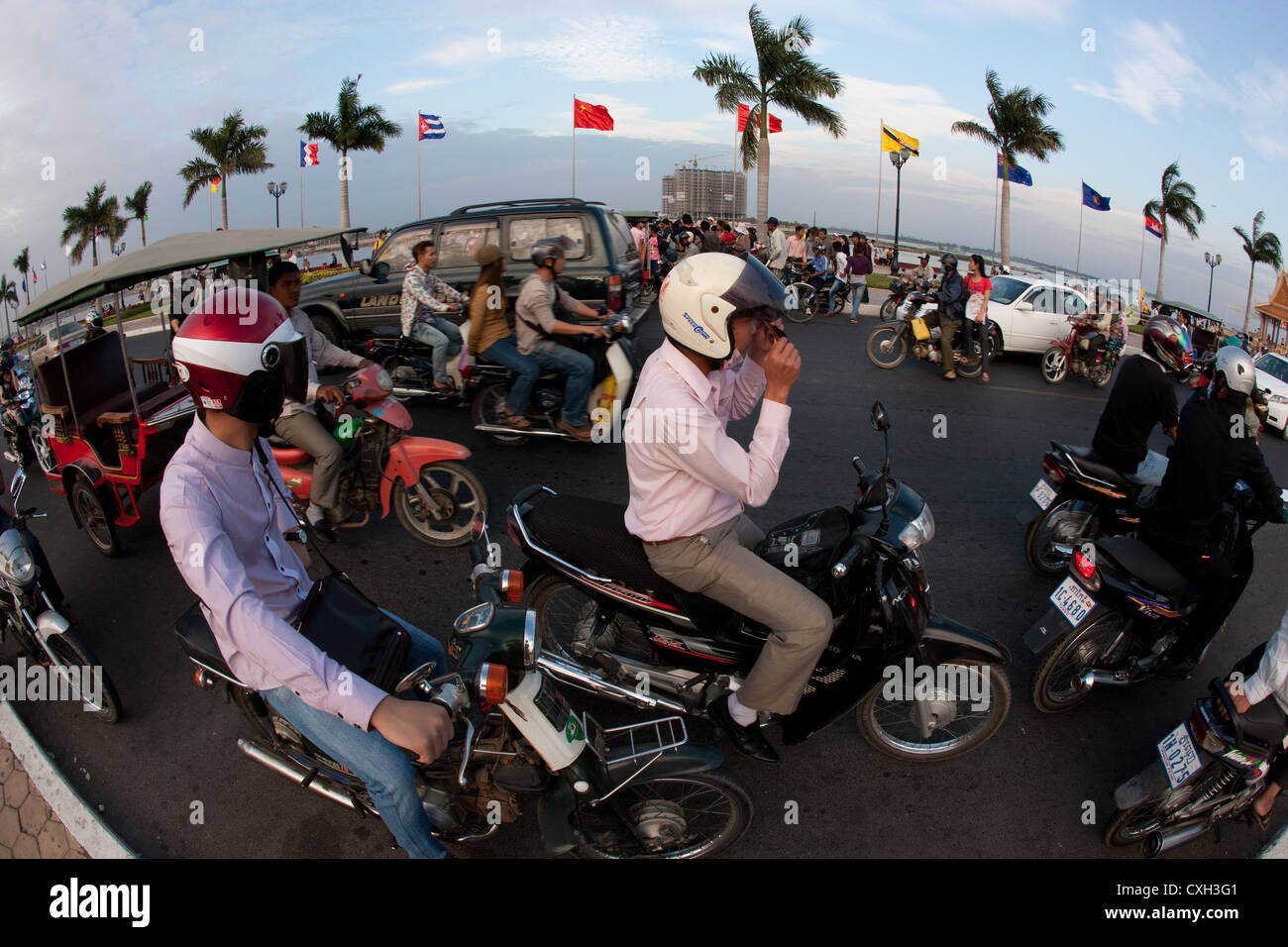 Motorcycles crowd the street along the waterfront in Phnom Penh ...
