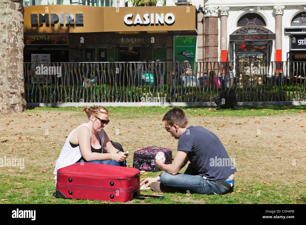 England, London, Leicester Square, Couple Playing Cards in front of ...