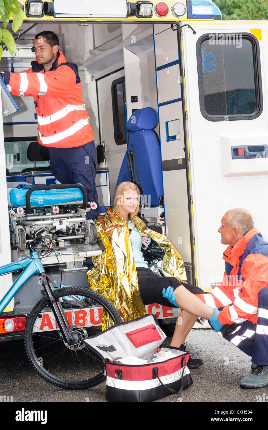 Emergency paramedics with woman bike accident in ambulance help injury ...