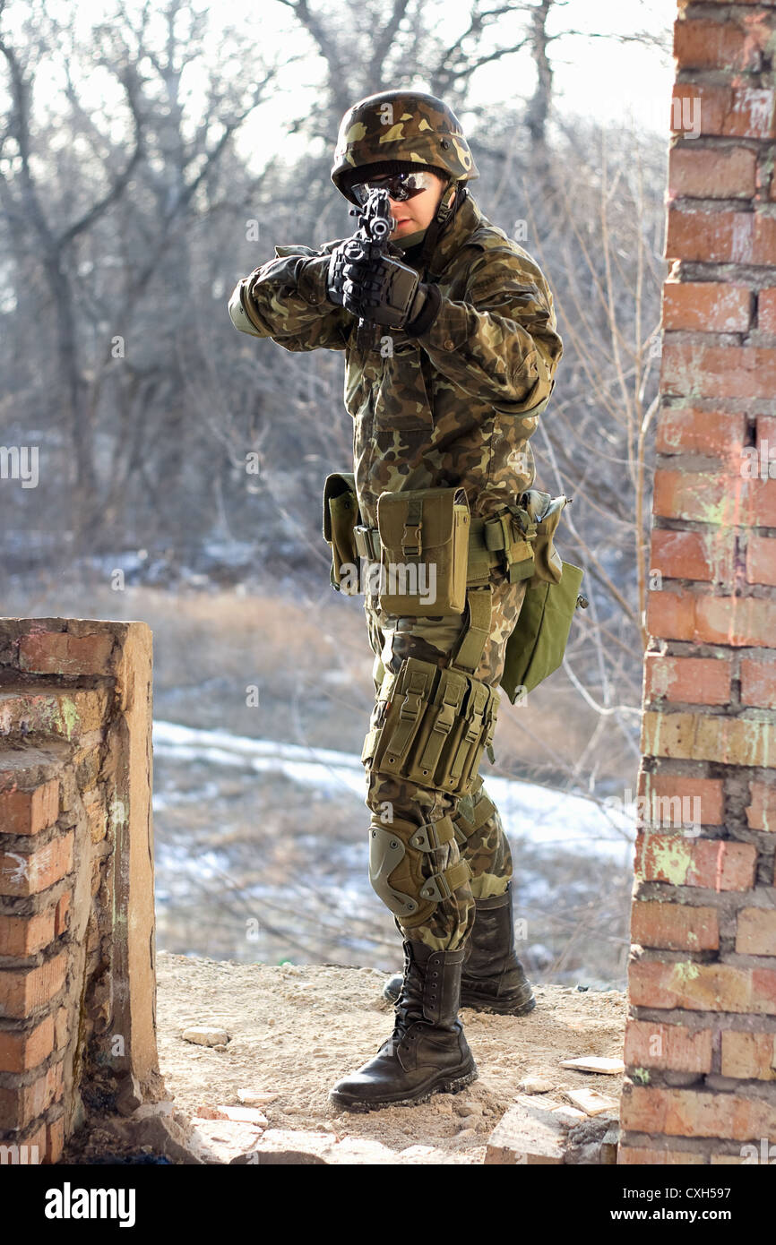 Soldier near wall with a gun Stock Photo - Alamy