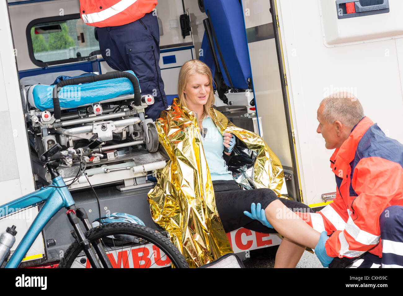 Emergency paramedics with woman bike accident in ambulance help injury ...