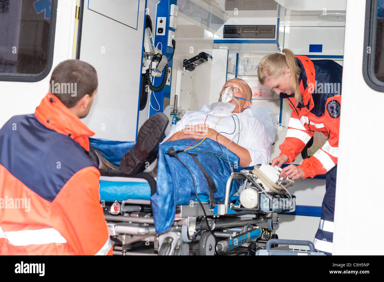Paramedics putting patient man oxygen mask in ambulance car Stock Photo ...