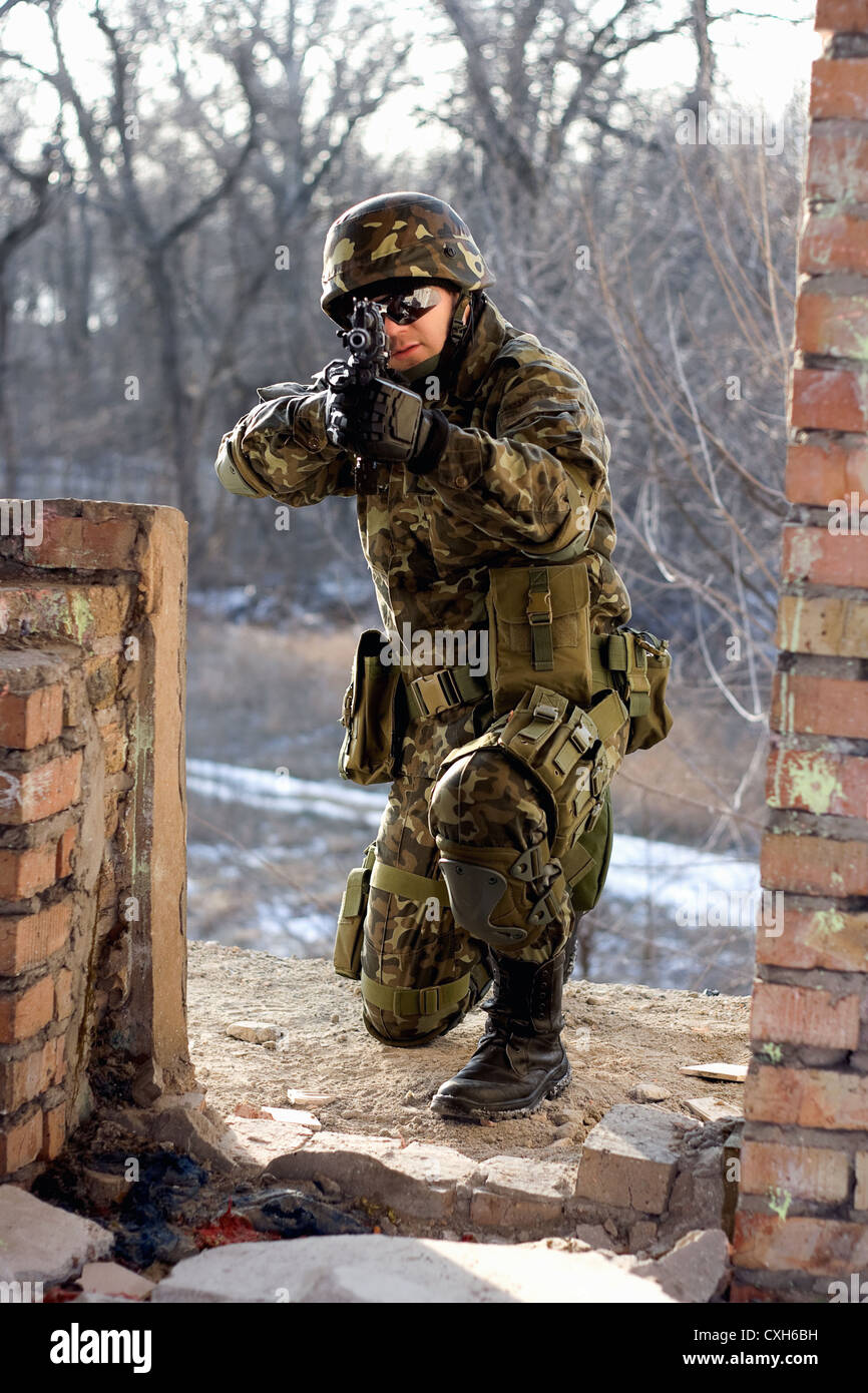 Soldier sitting near wall with a gun Stock Photo - Alamy