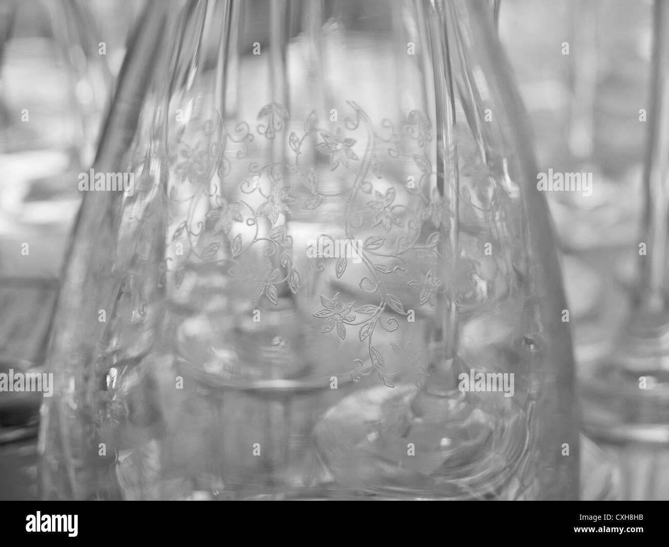 Monochrome detail of a transparent glass bottle, with a decorative ...