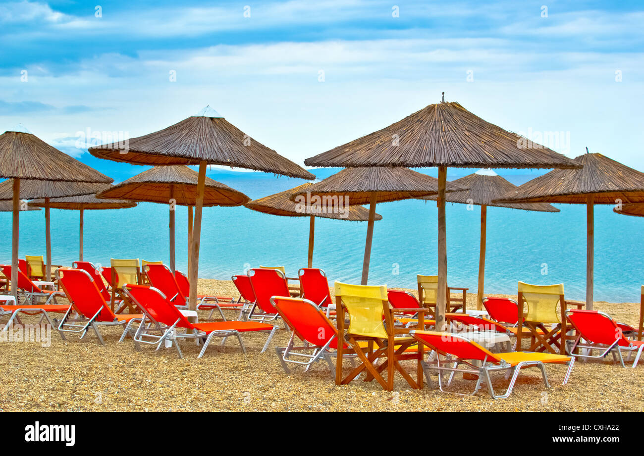 empty sun beds with umbrellas on the beautiful beach Stock Photo - Alamy