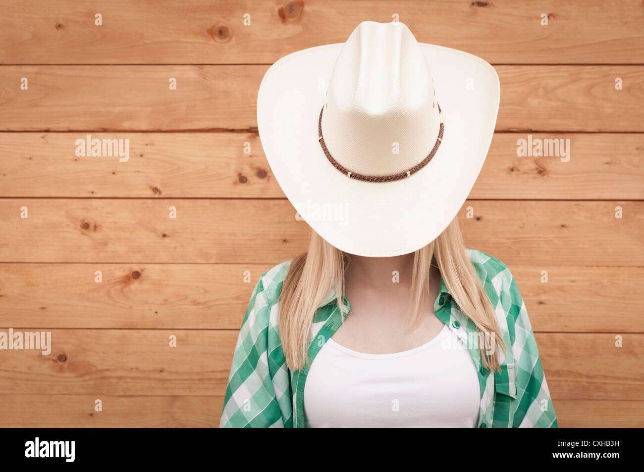 Germany, Teenage girl covering face with cowboy hat Stock Photo - Alamy