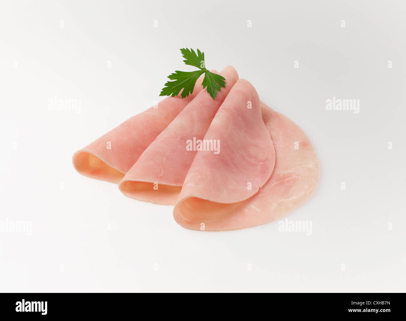 Cooked ham slices with parsley on white background Stock Photo - Alamy