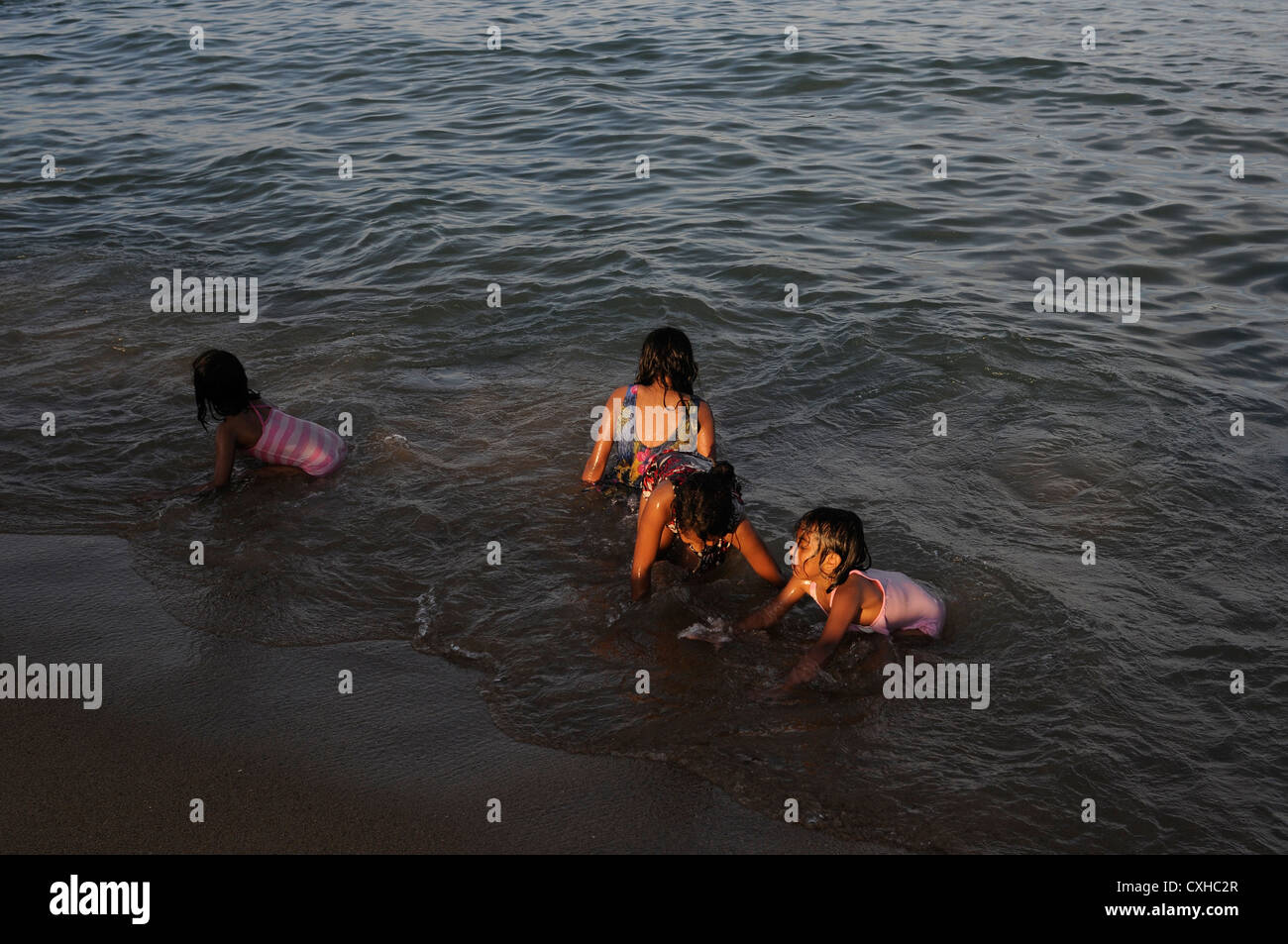four children playing in the seaside Stock Photo - Alamy