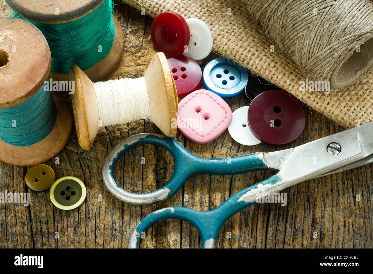 Spools of threads and buttons on old wooden table Stock Photo - Alamy