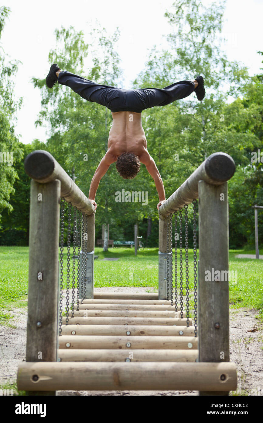 Germany, Bavaria, Young man doing handstand on railing Stock Photo - Alamy