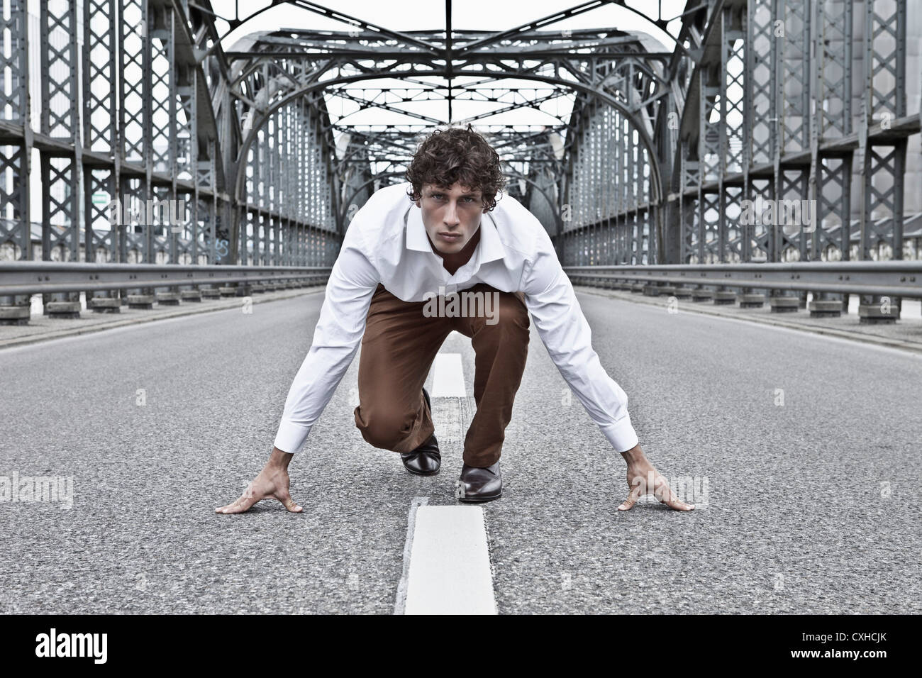 Germany, Bavaria, Young businessman in starting position on bridge ...
