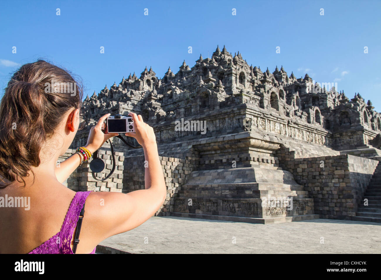 Indonesia, Young woman taking photograph of Borobudur Temple Stock ...
