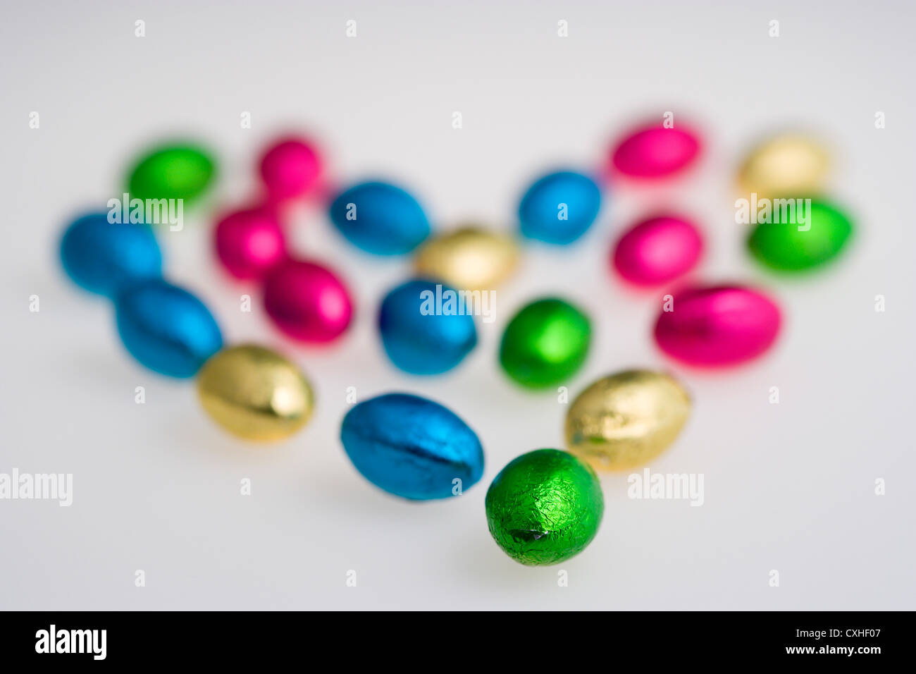 Colourful foil wrapped chocolates on white background Stock Photo - Alamy