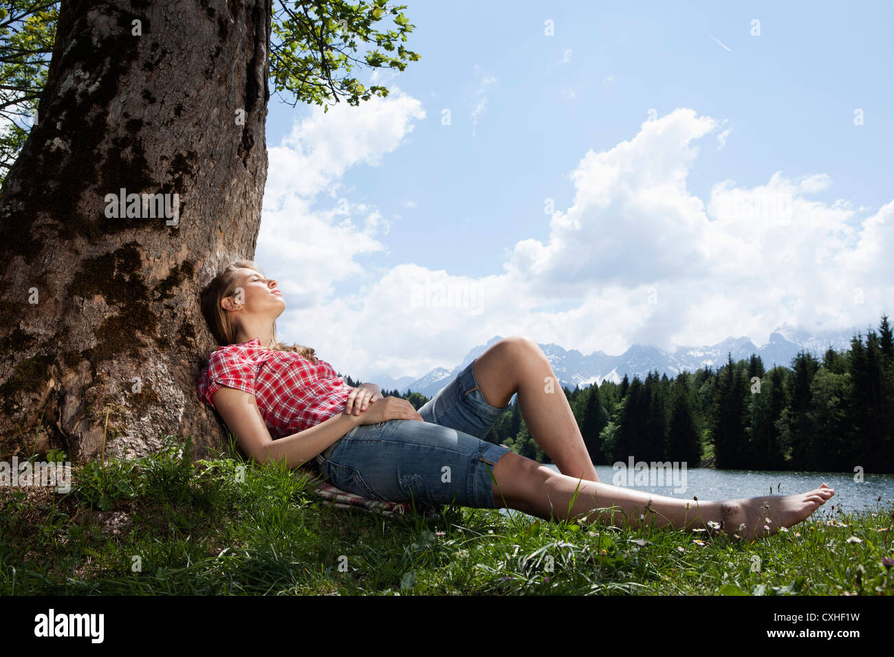 Woman lying under the tree hi-res stock photography and images - Alamy