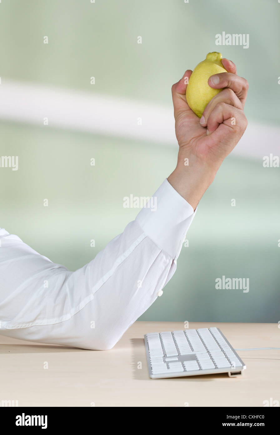 Mid adult man pressing lemon Stock Photo - Alamy