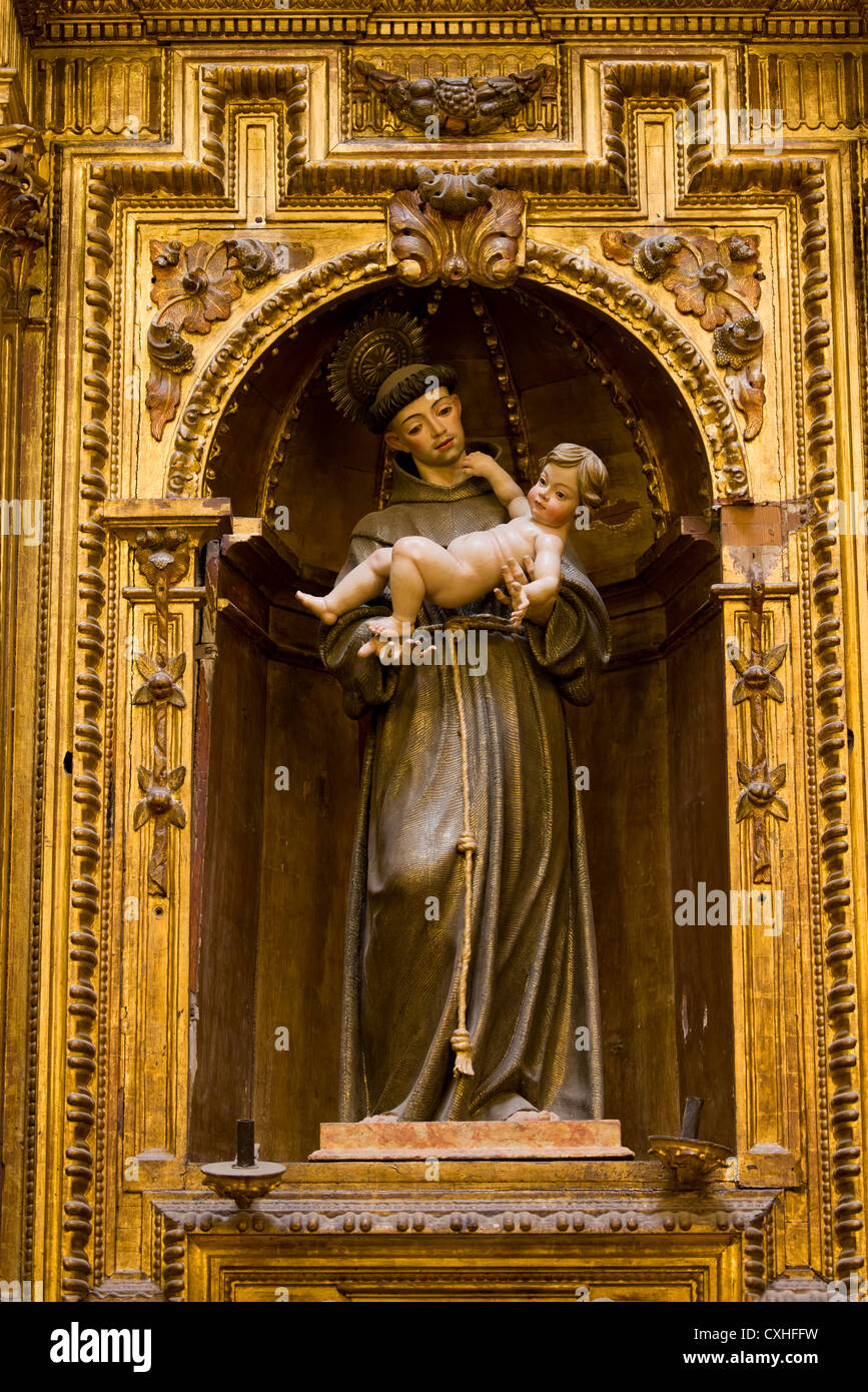 An old historic sculpture of baby Jesus Christ and a monk in golden ...