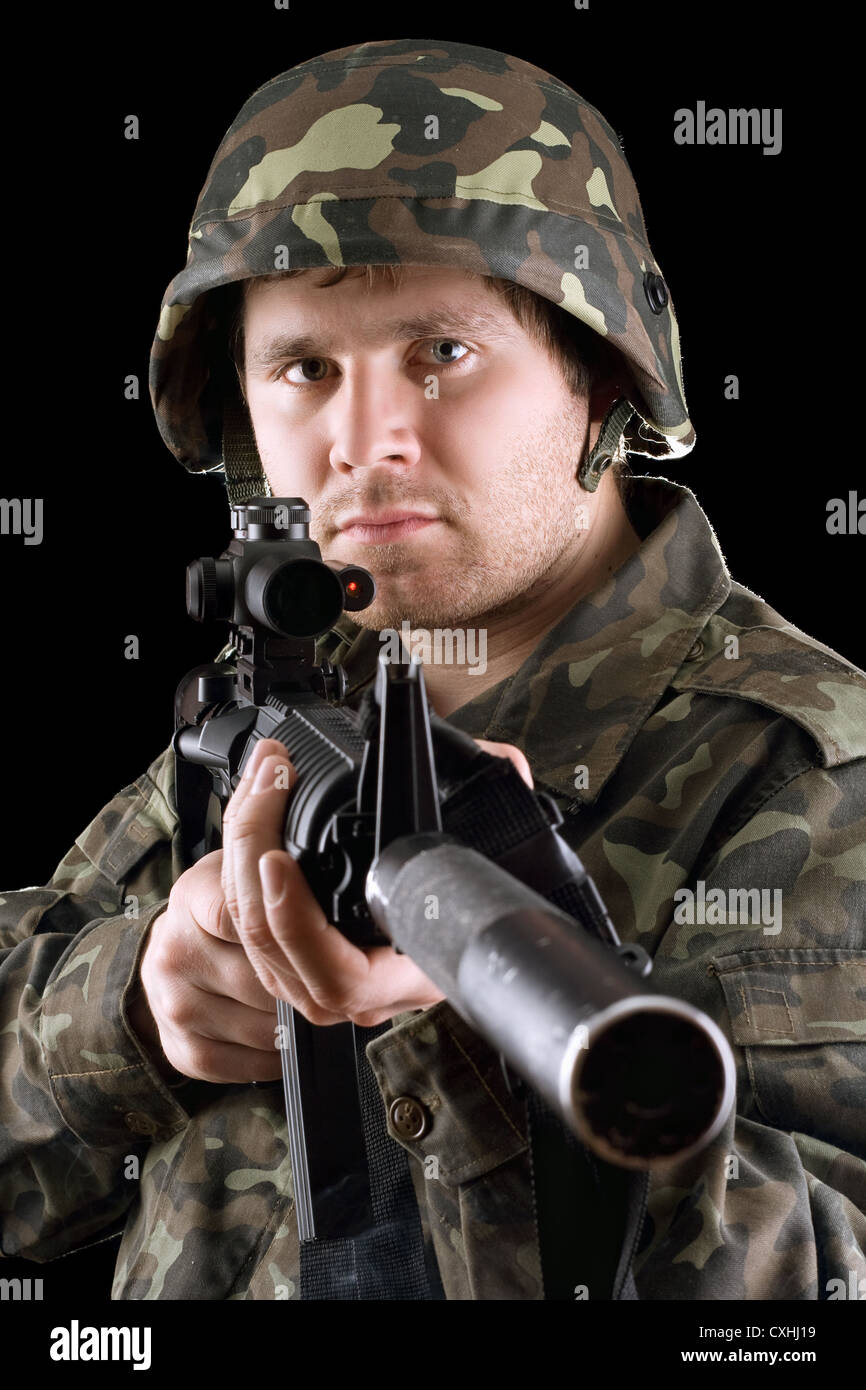 Soldier holding a gun in studio Stock Photo - Alamy