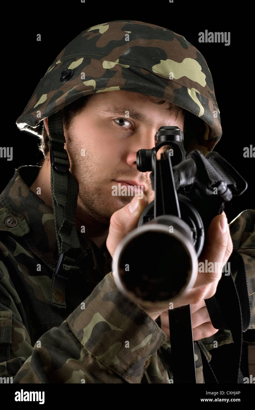 Ready soldier aiming a rifle in studio Stock Photo - Alamy