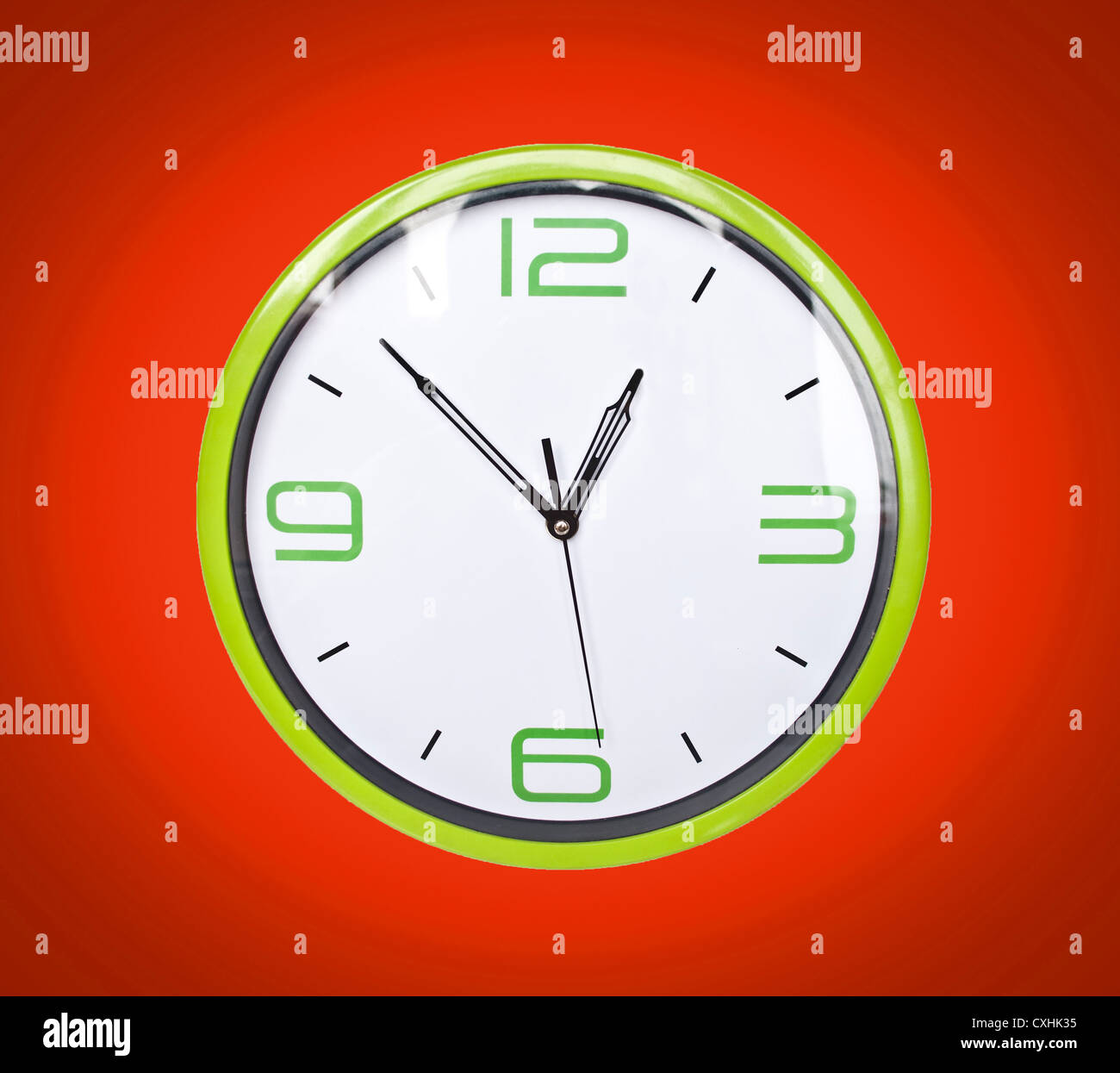 Retro green clock on red background Stock Photo - Alamy