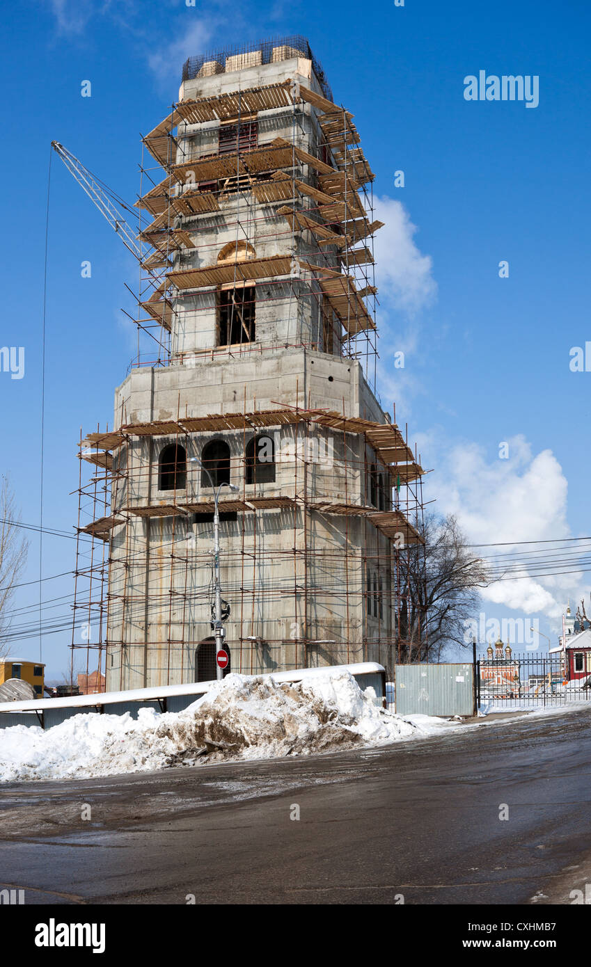 Tower building under construction with crane over blue sky background ...