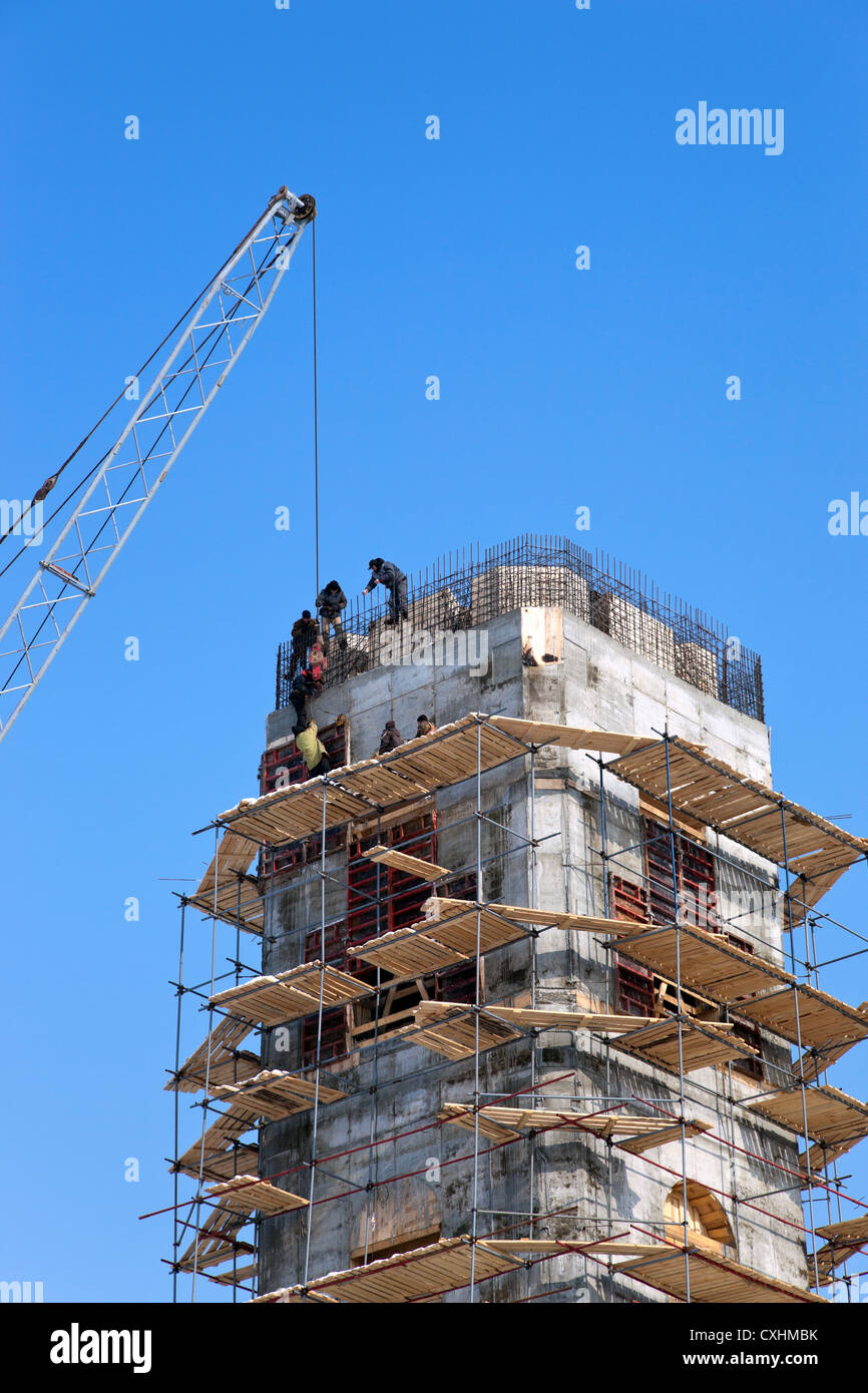 Tower building under construction with crane over blue sky background ...