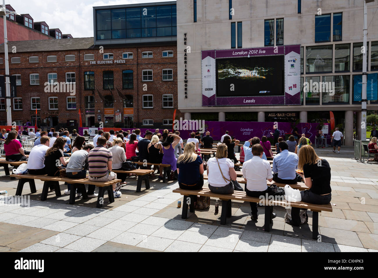 People watching a BBC feed of the London 2012 Olympics on a big screen ...
