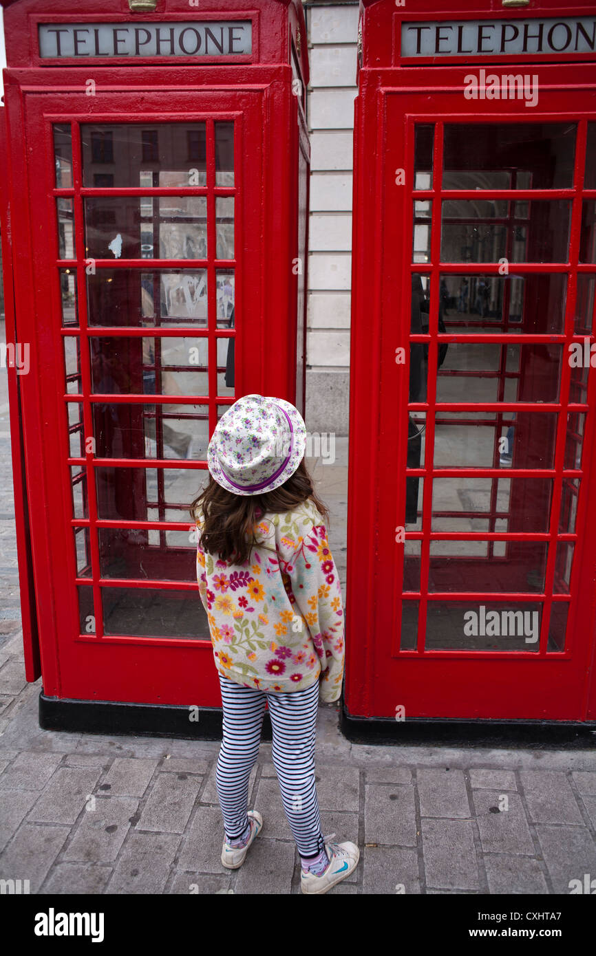 Girl looking telephone box Stock Photo - Alamy