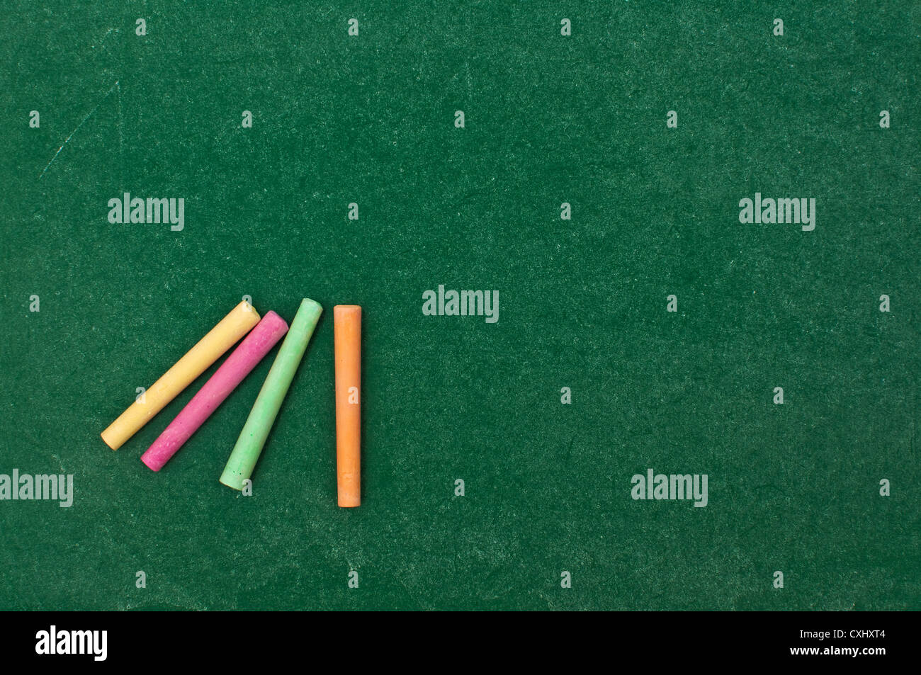 Colorful chalks on grungy green chalkboard texture Stock Photo - Alamy