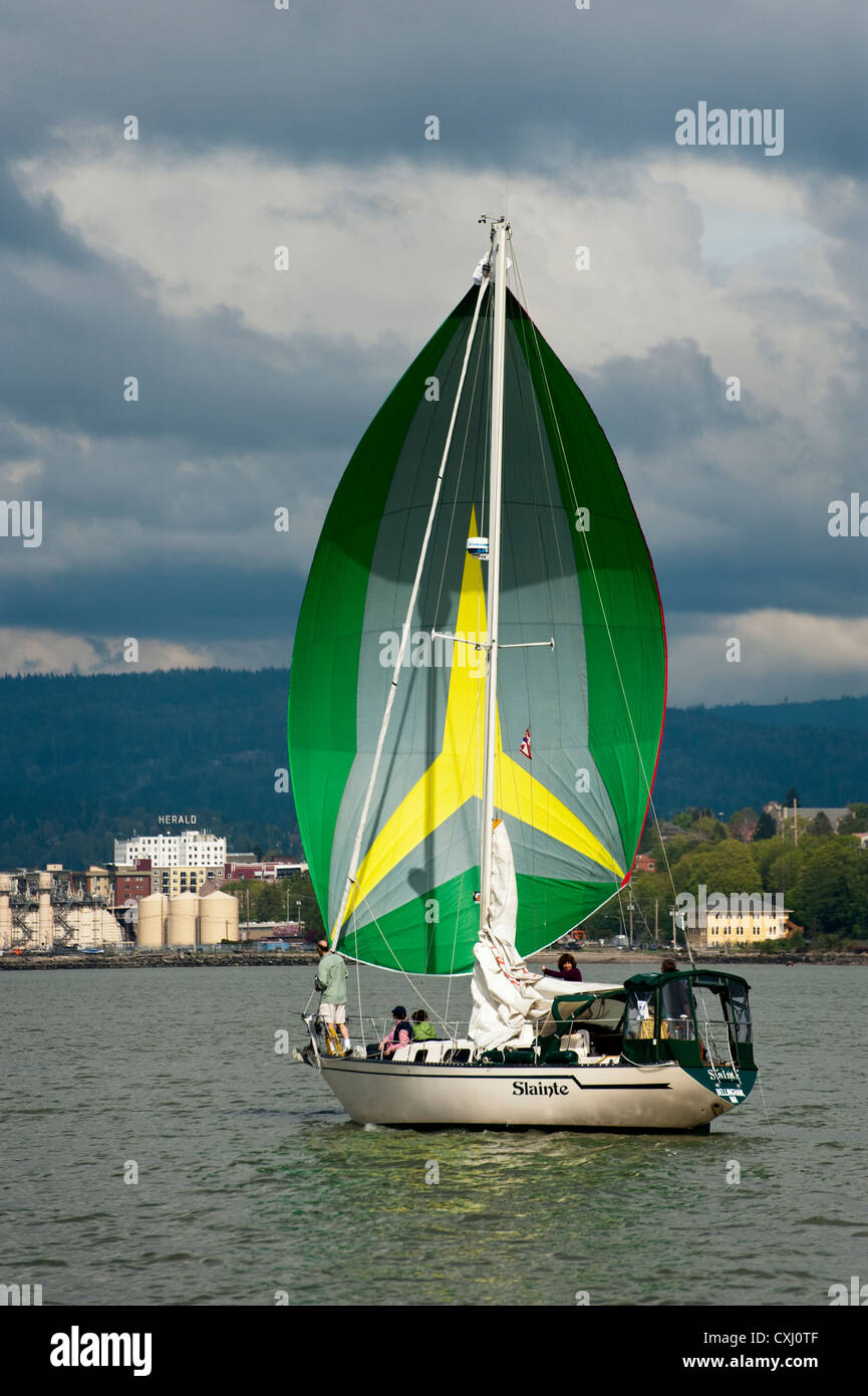 A sailboat on Bellingham Bay raises a colorful spinnaker sail during a ...