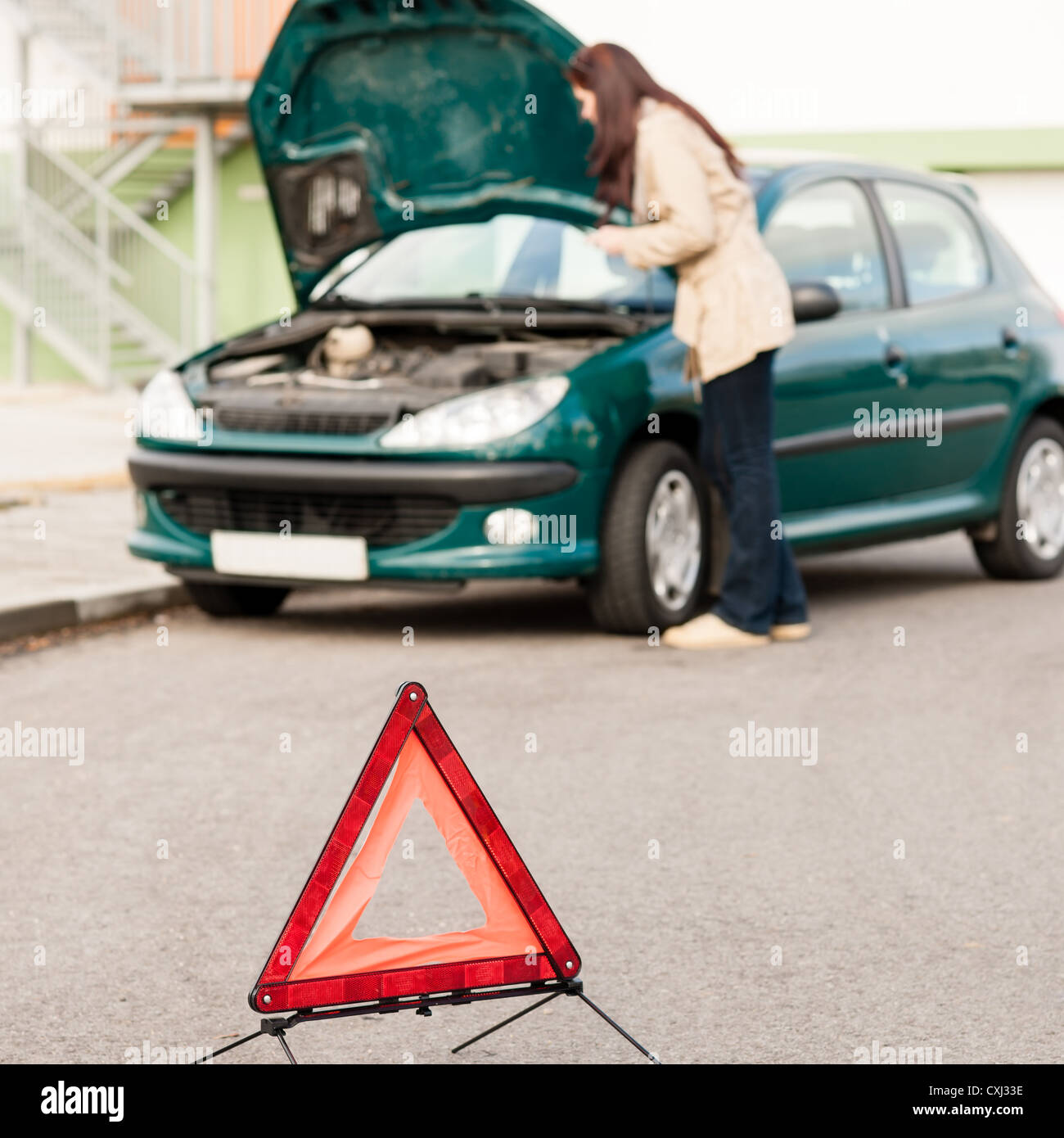 Woman trying to fix her broken car breakdown sign triangle Stock Photo ...