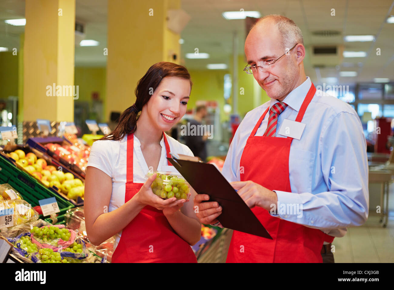 Germany, Cologne, Man and woman with grapes in supermarket Stock Photo ...