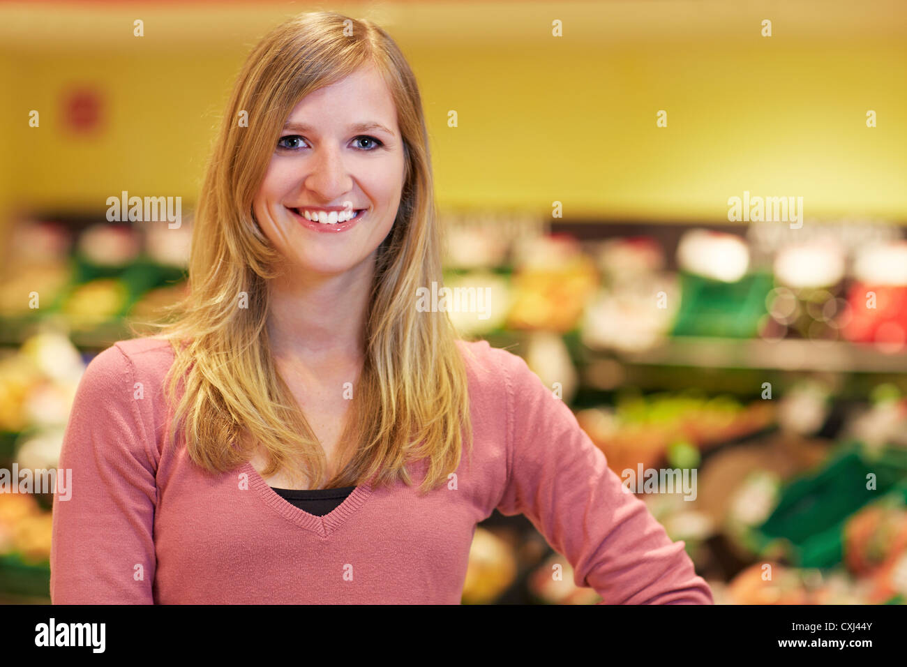Germany, Cologne, Young woman in supermarket, smiling, portrait Stock ...