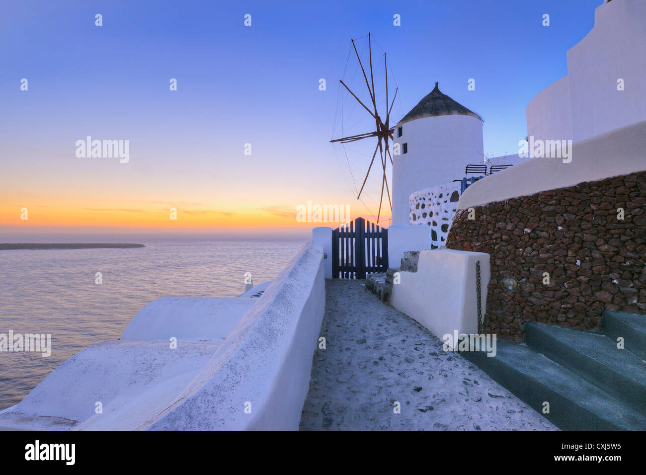 Greece, View of Oia village with traditional Greek windmills in sunset ...