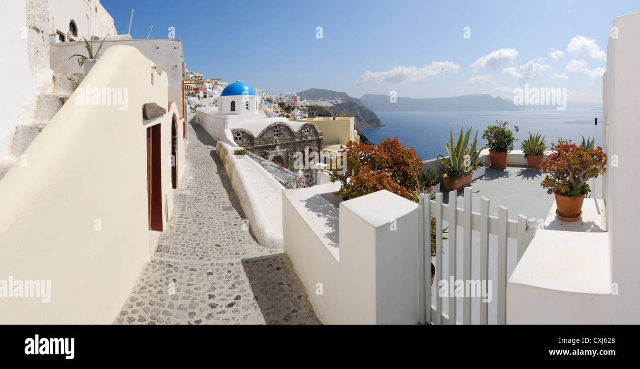 Greece, View of Oia village with cobbled path and gate at Santorini ...