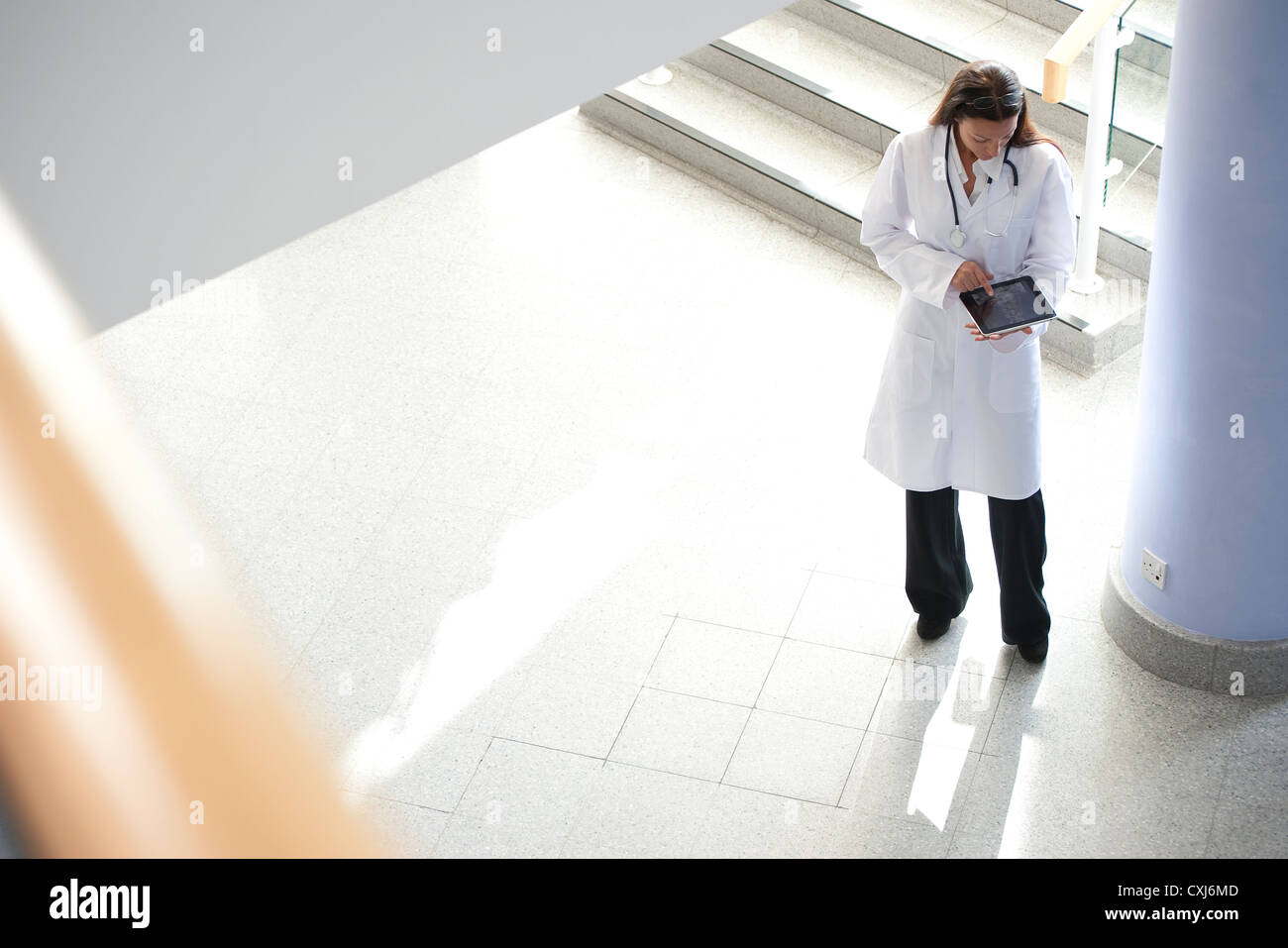 female doctor standing in corridor using ipad Stock Photo - Alamy