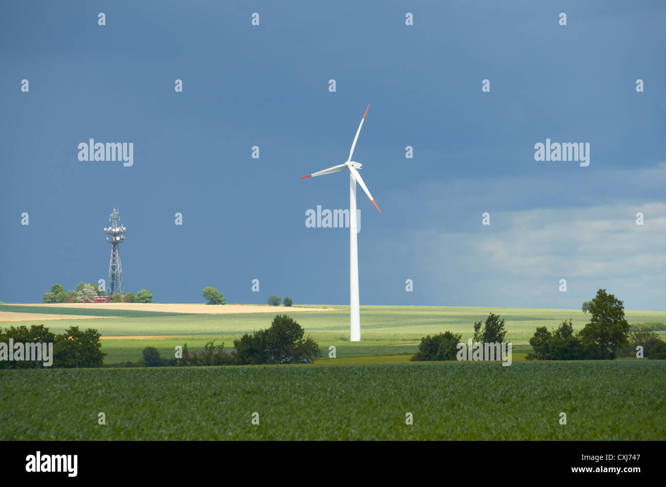 Germany, View of wind turbine and radio tower on landscape Stock Photo ...