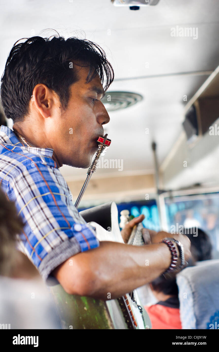 An indonesian man busking by singing in the bus, asia scene Stock Photo ...