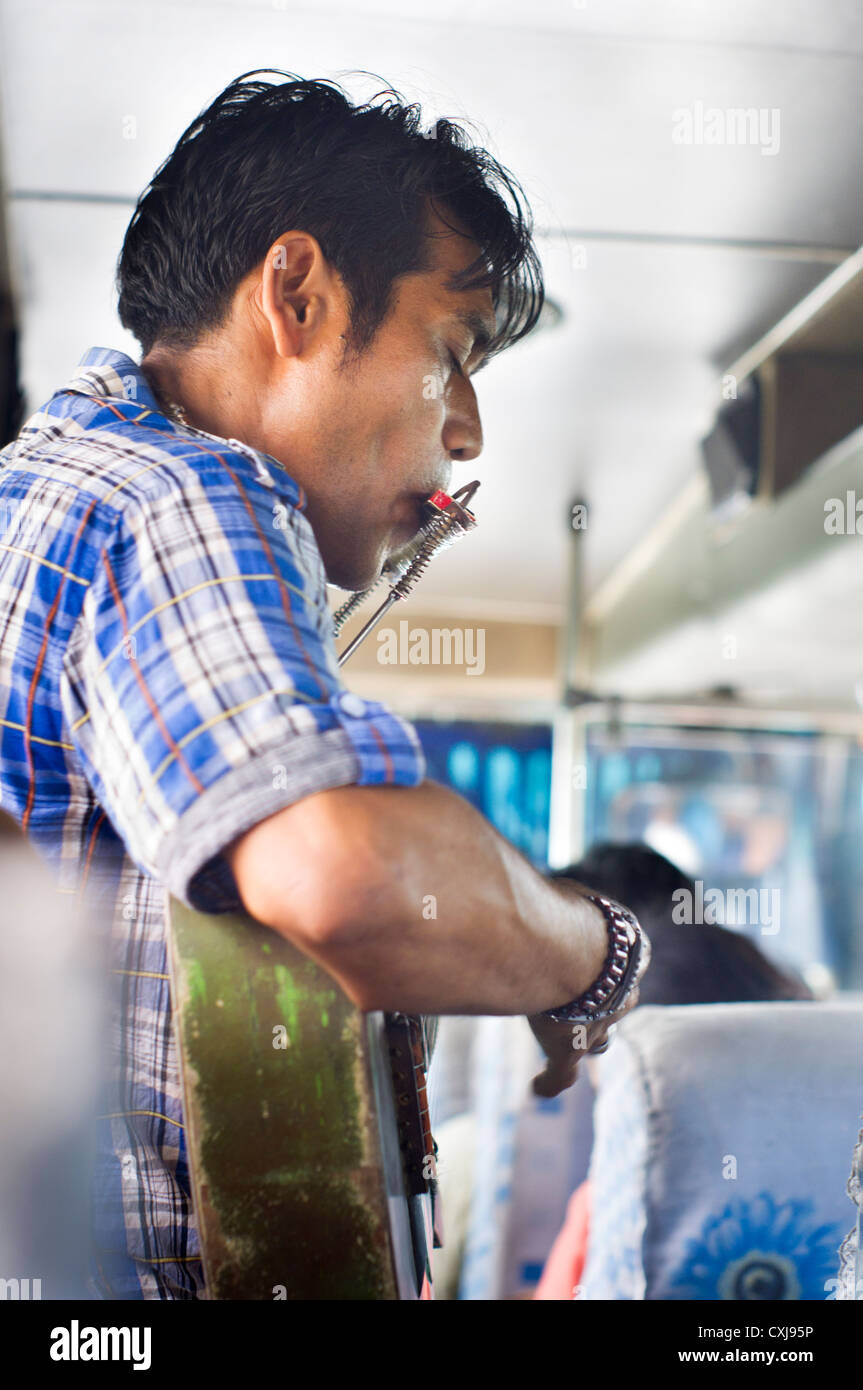 An indonesian man busking by singing in the bus, asia scene Stock Photo ...