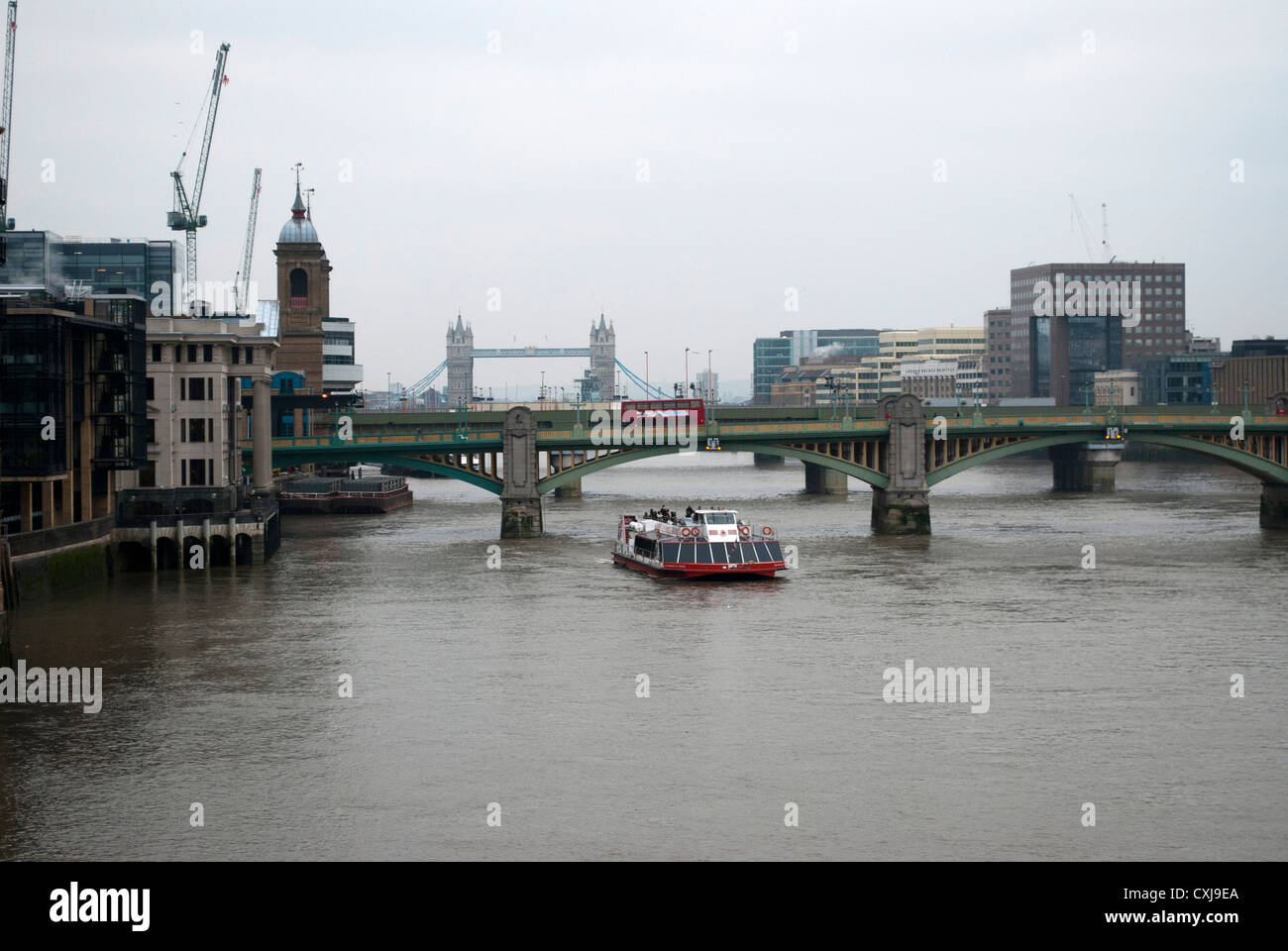 River boat about to pass under Southwark Bridge over the Thames with ...
