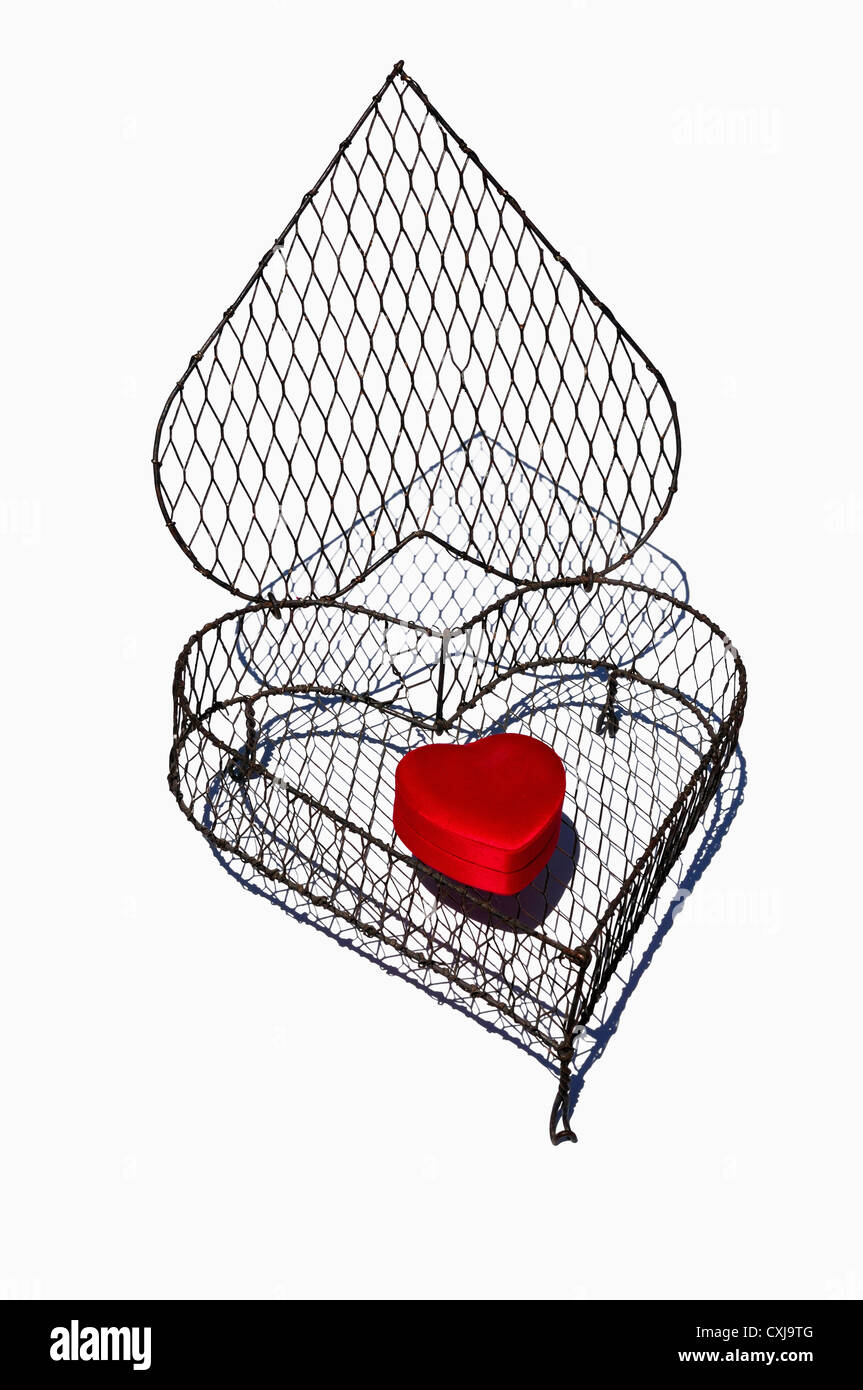 Heart shape cage made by wire with red heart on white background, close ...
