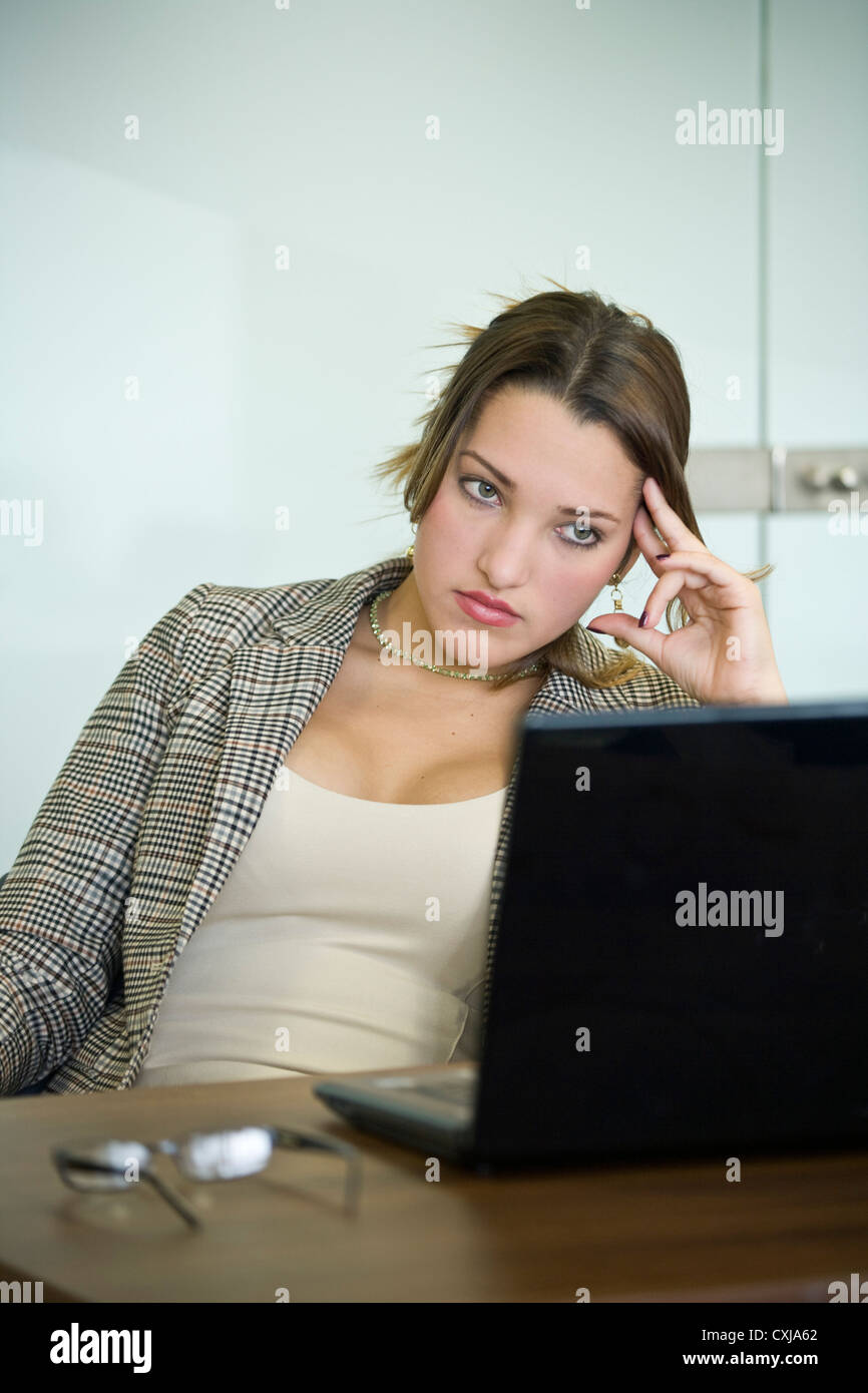 Young office worker leaning back in chair looking fed up Stock Photo ...