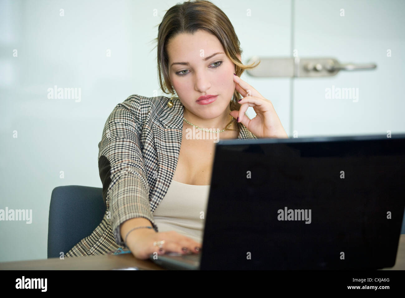 Young office worker leaning back in chair looking fed up Stock Photo ...