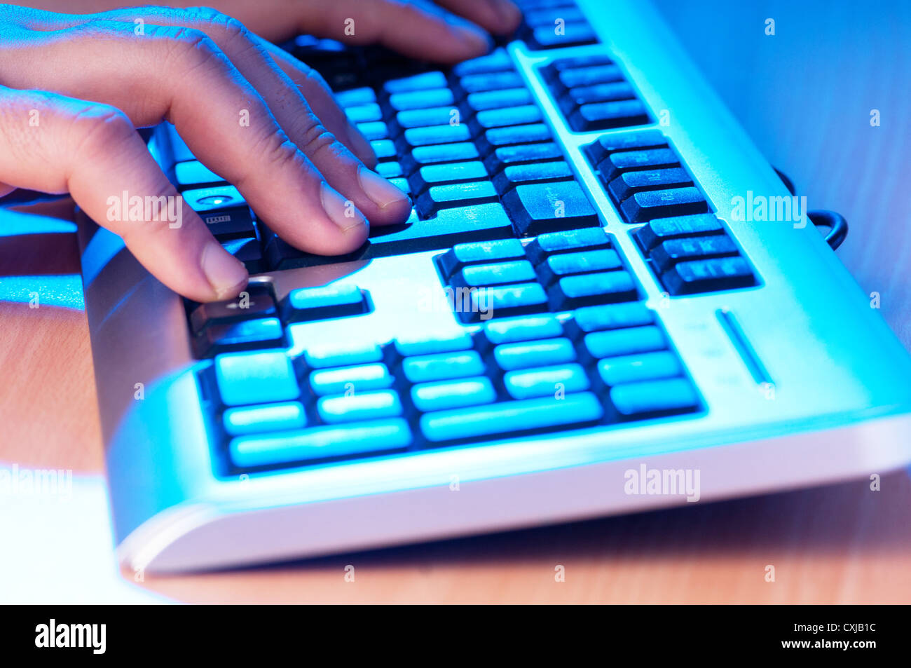 Two hands working on the silver keyboard Stock Photo - Alamy
