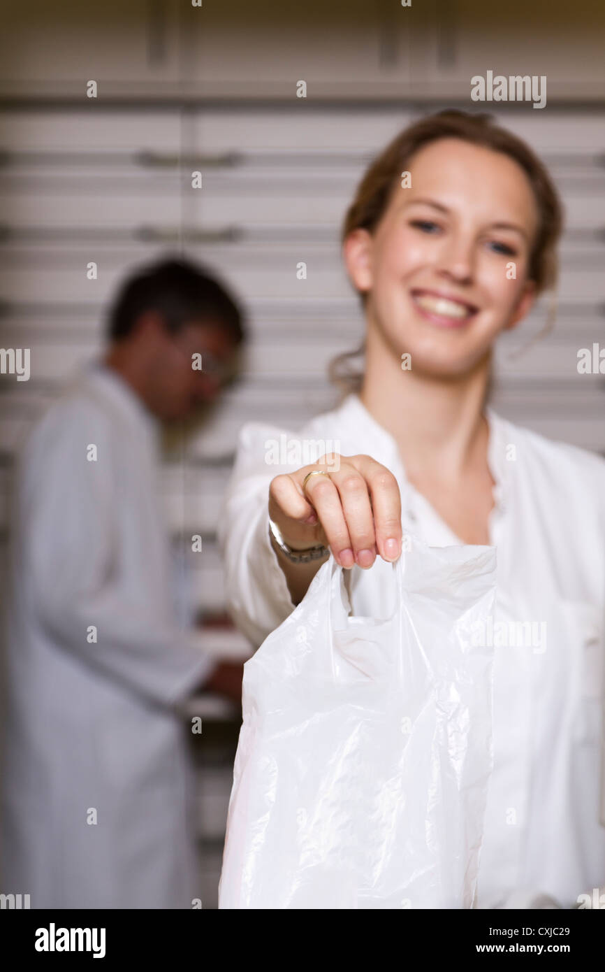 Woman handing over bag hi-res stock photography and images - Alamy
