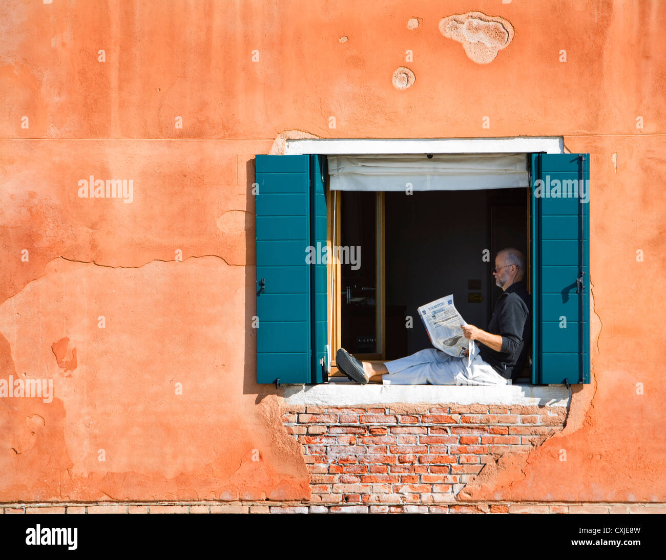 Man reading newspaper in the shade in Venice Stock Photo - Alamy