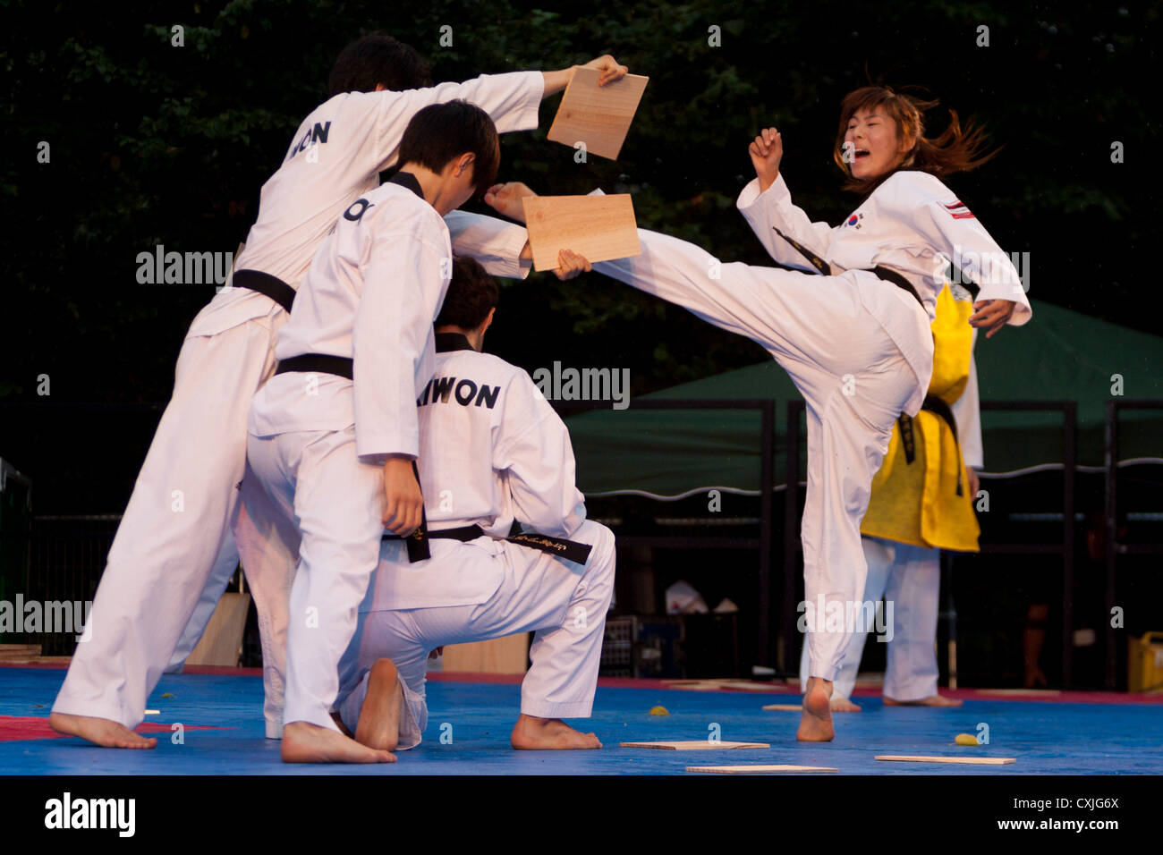 Woman smashes wood with kick duringTaekwondo demonstration by Kukkiwon ...