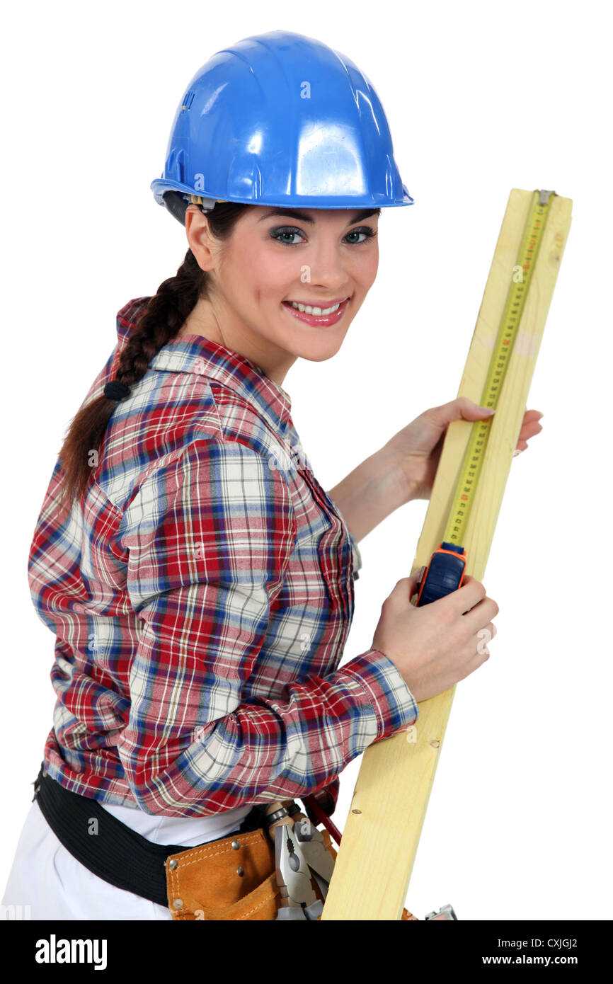 Construction worker measuring a piece of wood Stock Photo - Alamy