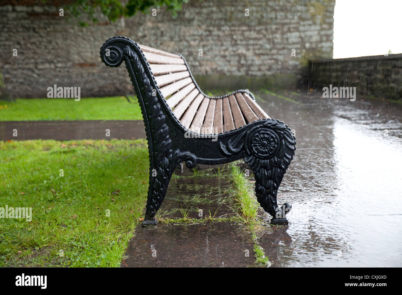 Forged park bench at rain Stock Photo - Alamy